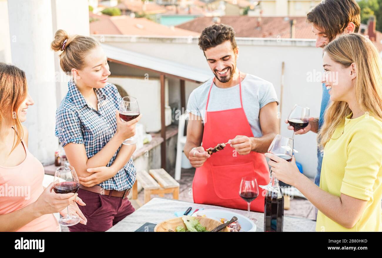 Happy friends having barbecue party on top of the roof - Young people ...