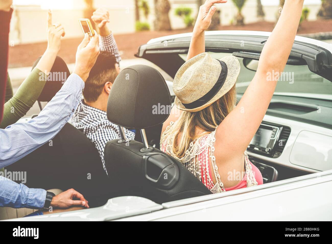 Happy millennial people having fun in convertible car on summer ...