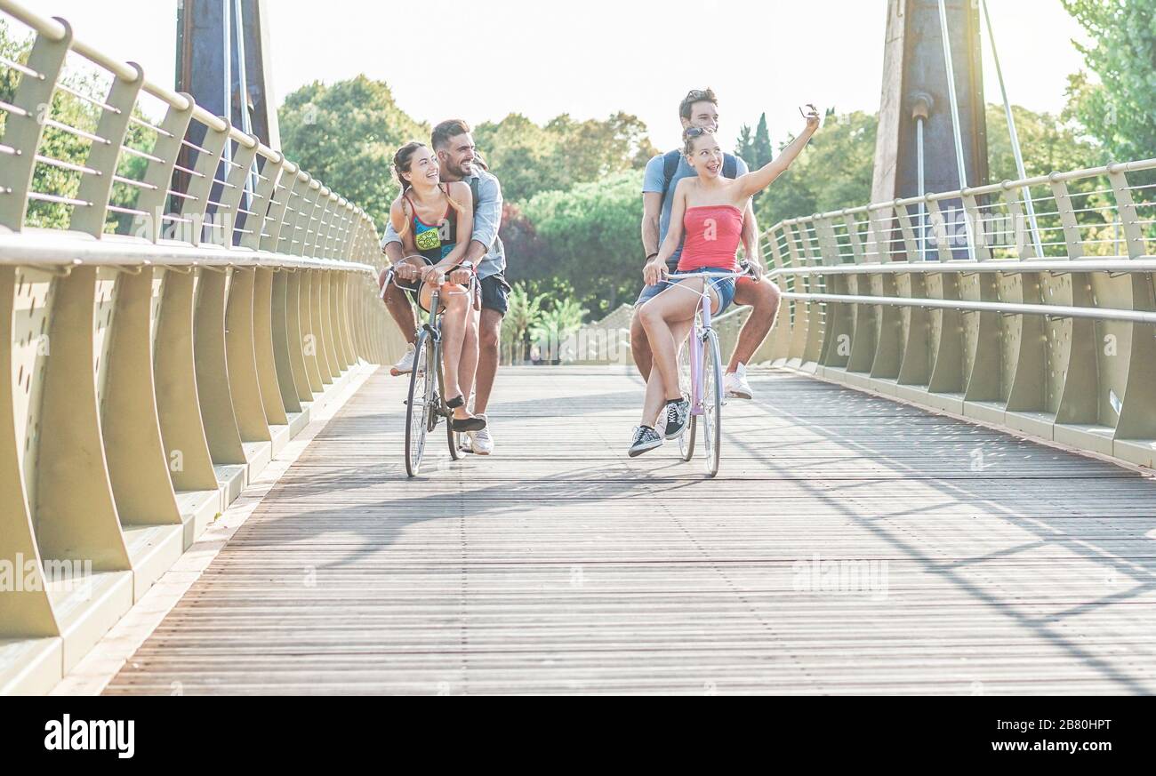 Happy friends taking photo with smartphone on bicycle outdoor - Young ...