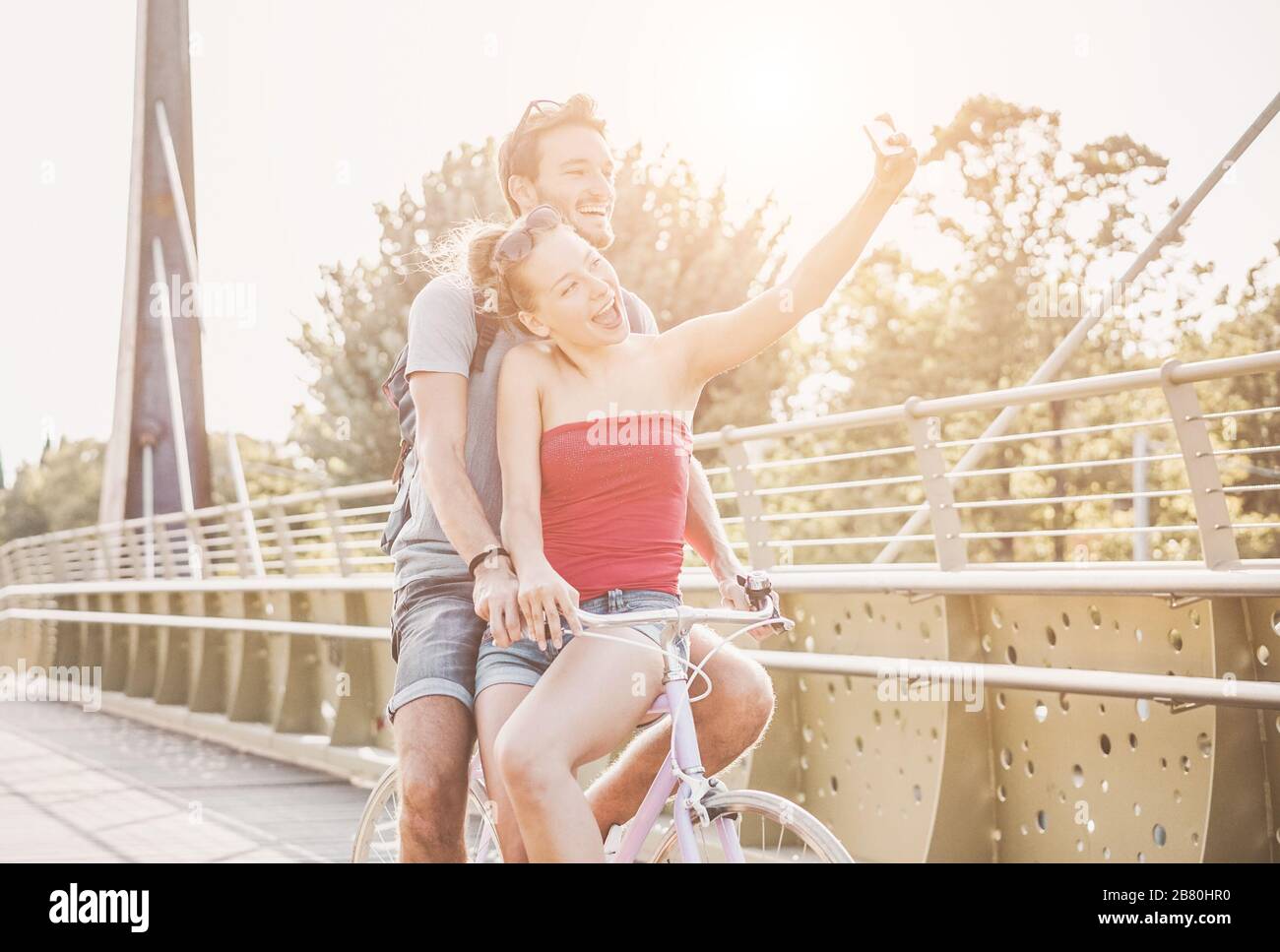 Happy Millennial Couple Taking Photo Selfie With Smartphone On Bicycle