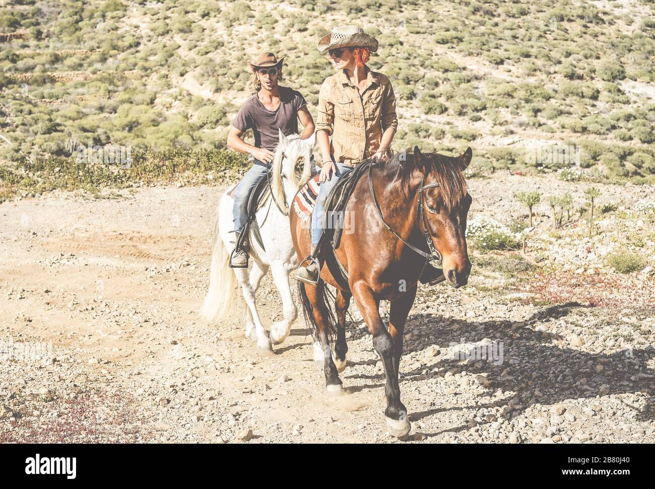 Couple riding horses in countryside nature tour - Happy people having ...