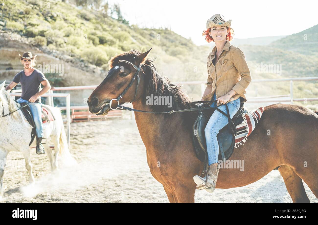 Couple riding horses inside corral ranch - Happy people having fun on ...