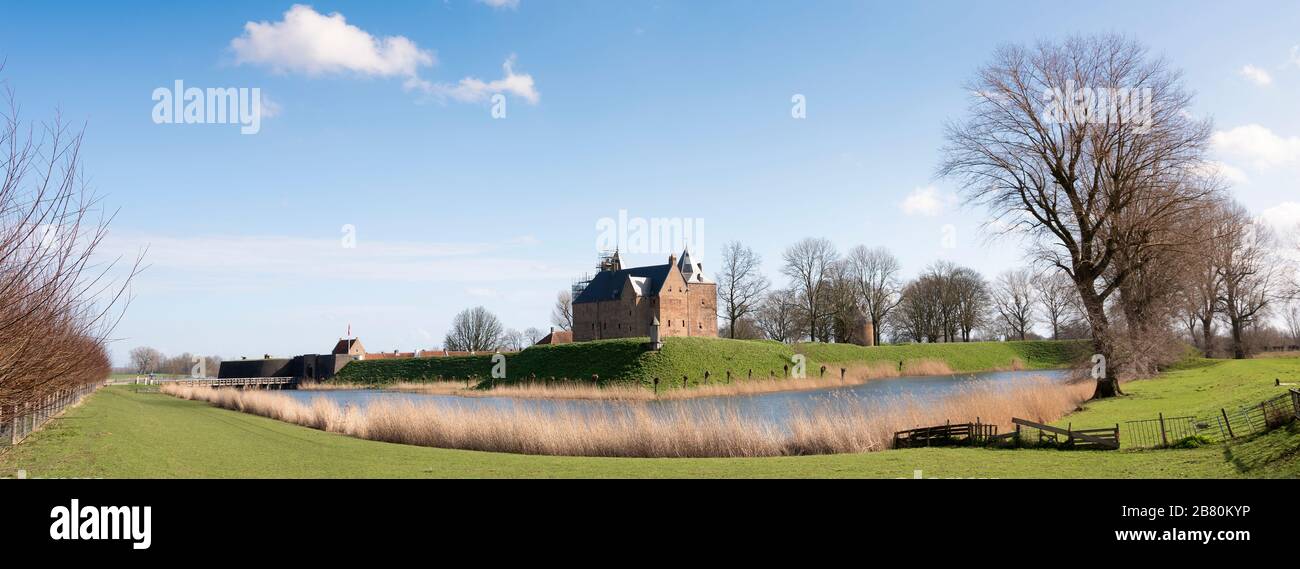 castle loevestein and moat under blue sky in the netherlands near river ...