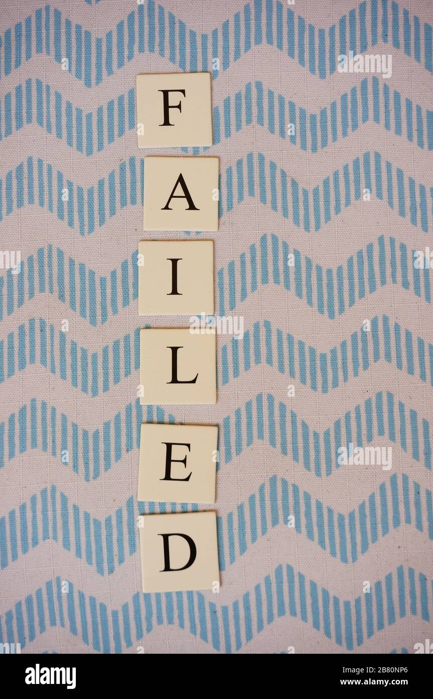 Word failed written by letters on small squares on a blue and white ...