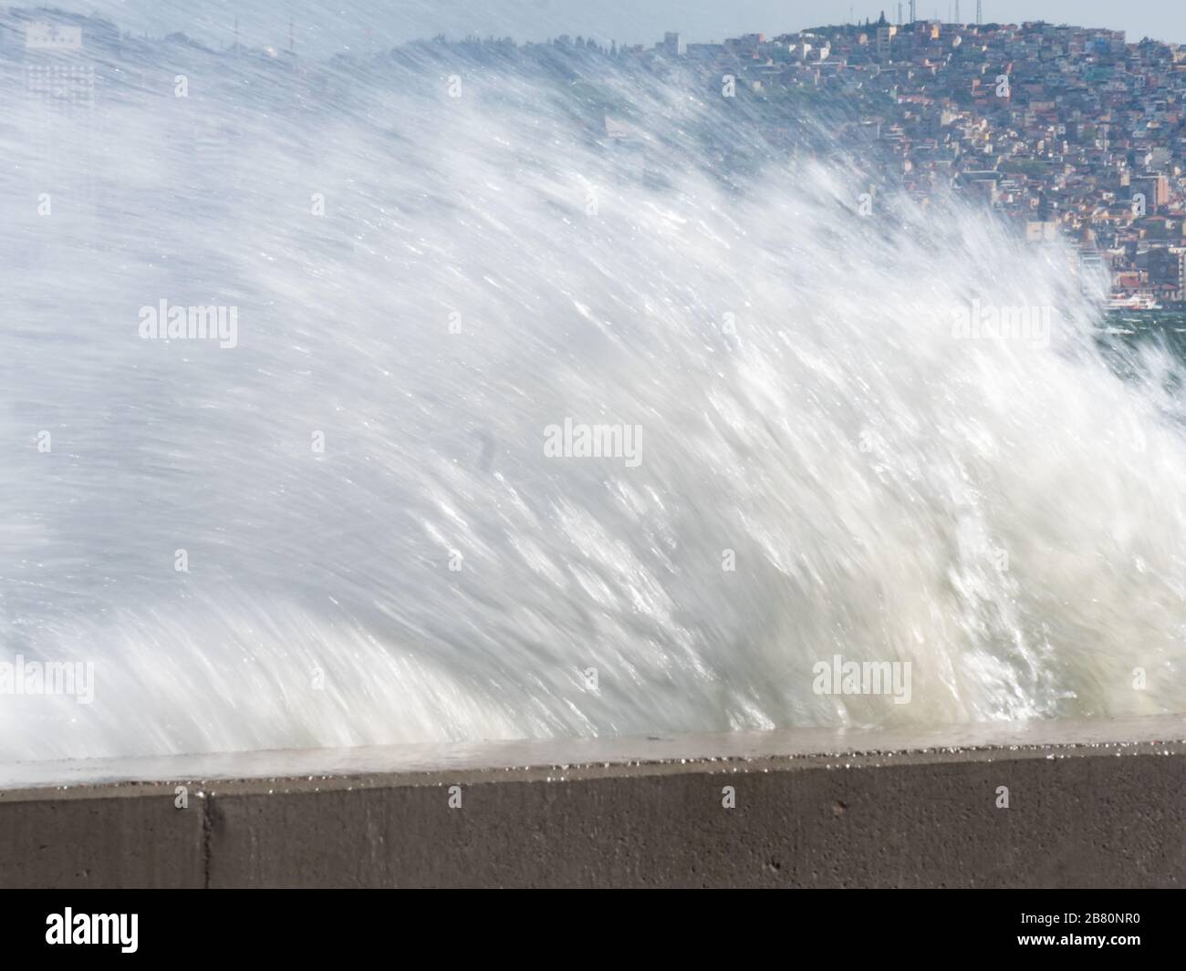 Waves hit the hard surface of concrete wall and splashing sea water ...