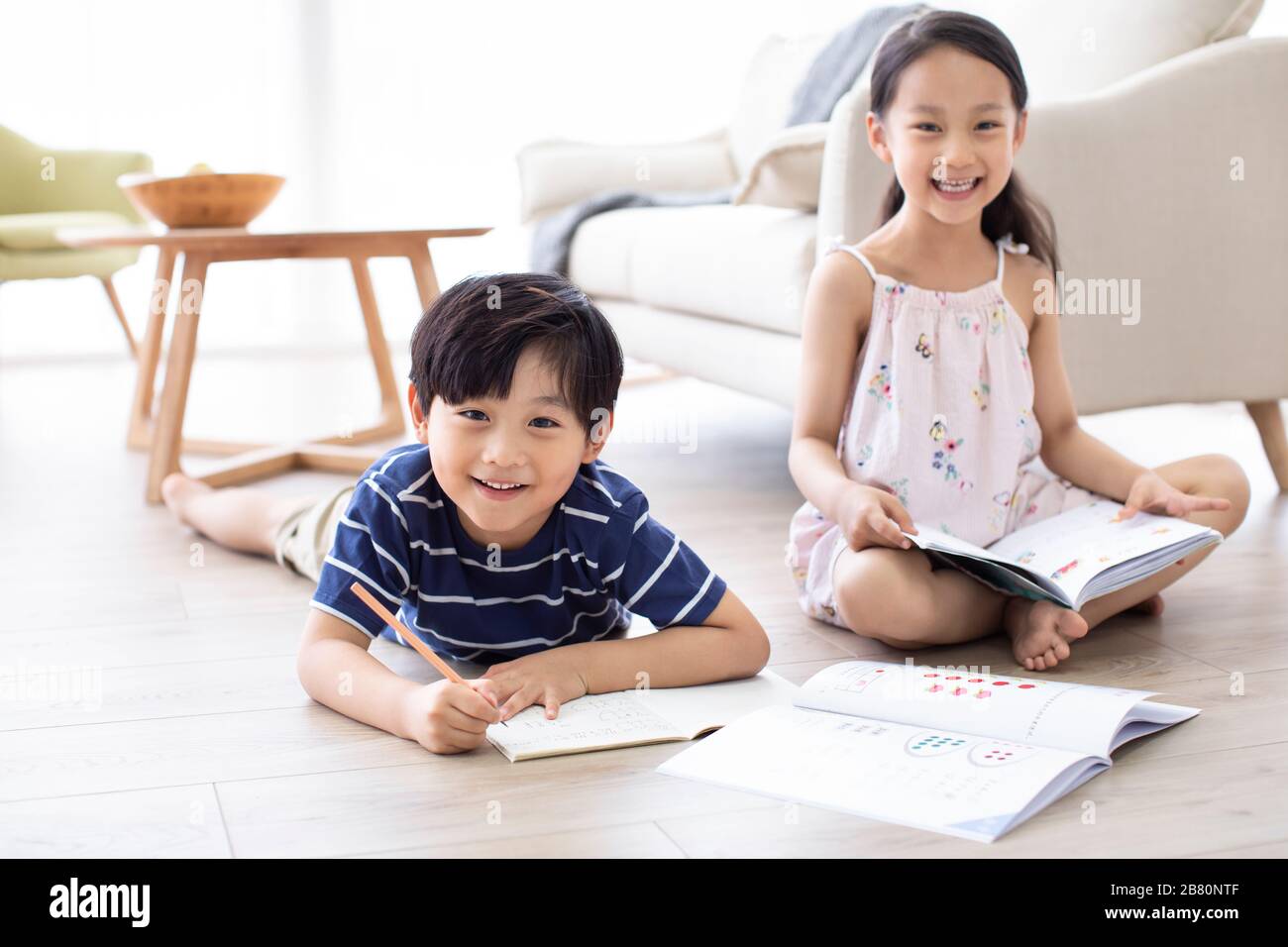 Happy Chinese sibling studying in living room Stock Photo - Alamy