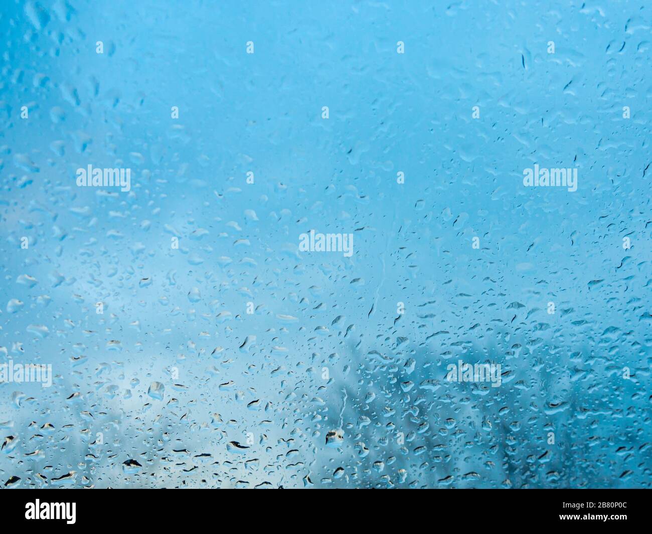 Wet window with rain drops and a cloudy sky outside background Stock ...