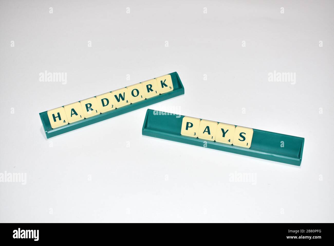 Scrabble tiles spell out Hardwork Pays. Motivational quote Scrabble ...