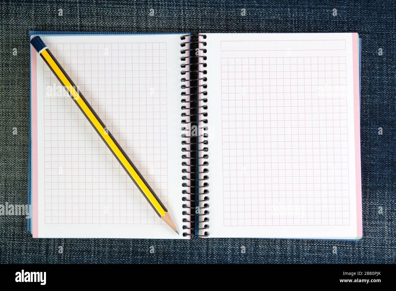 An open notebook on jeans and a pencil Stock Photo - Alamy