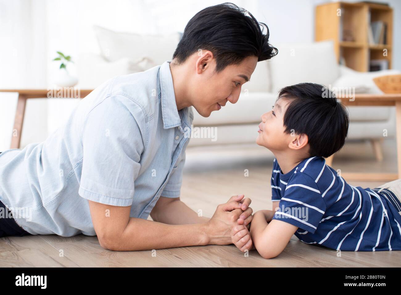 Chinese father and son lying on floor Stock Photo - Alamy