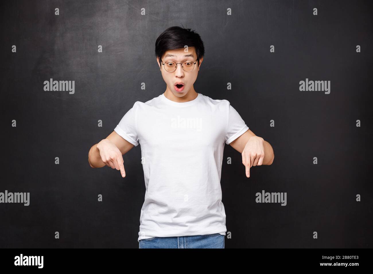 Astonished and amazed speechless asian guy see something shocking and ...