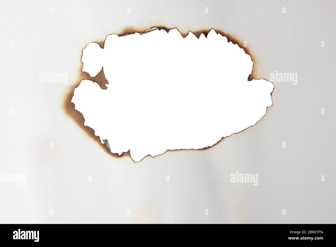 Burnt a hole in a sheet of paper Stock Photo - Alamy