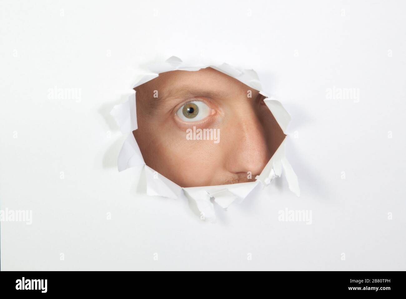 A secret look through the hole in the paper Stock Photo - Alamy