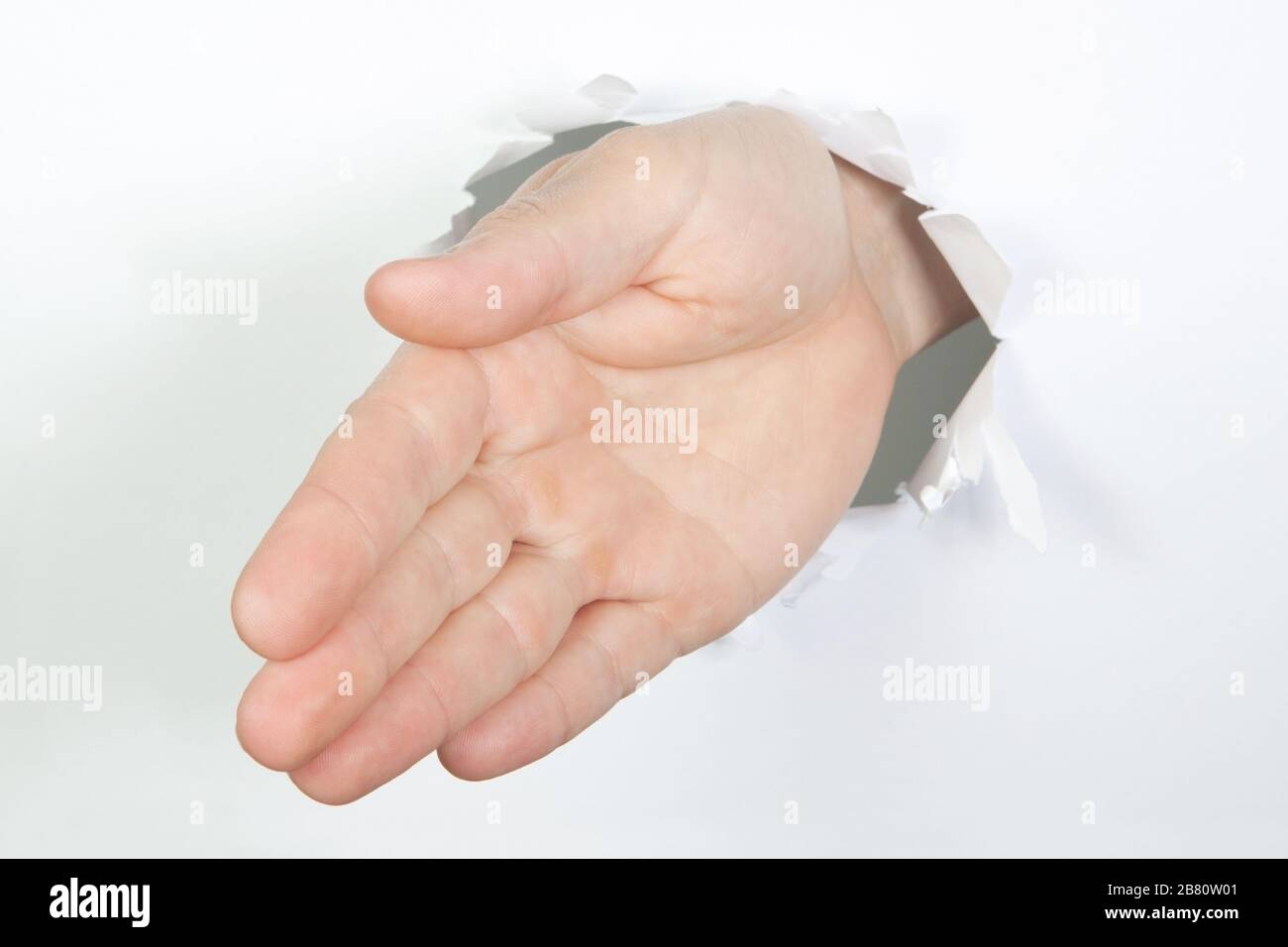 Welcome hand through a hole in the paper Stock Photo - Alamy