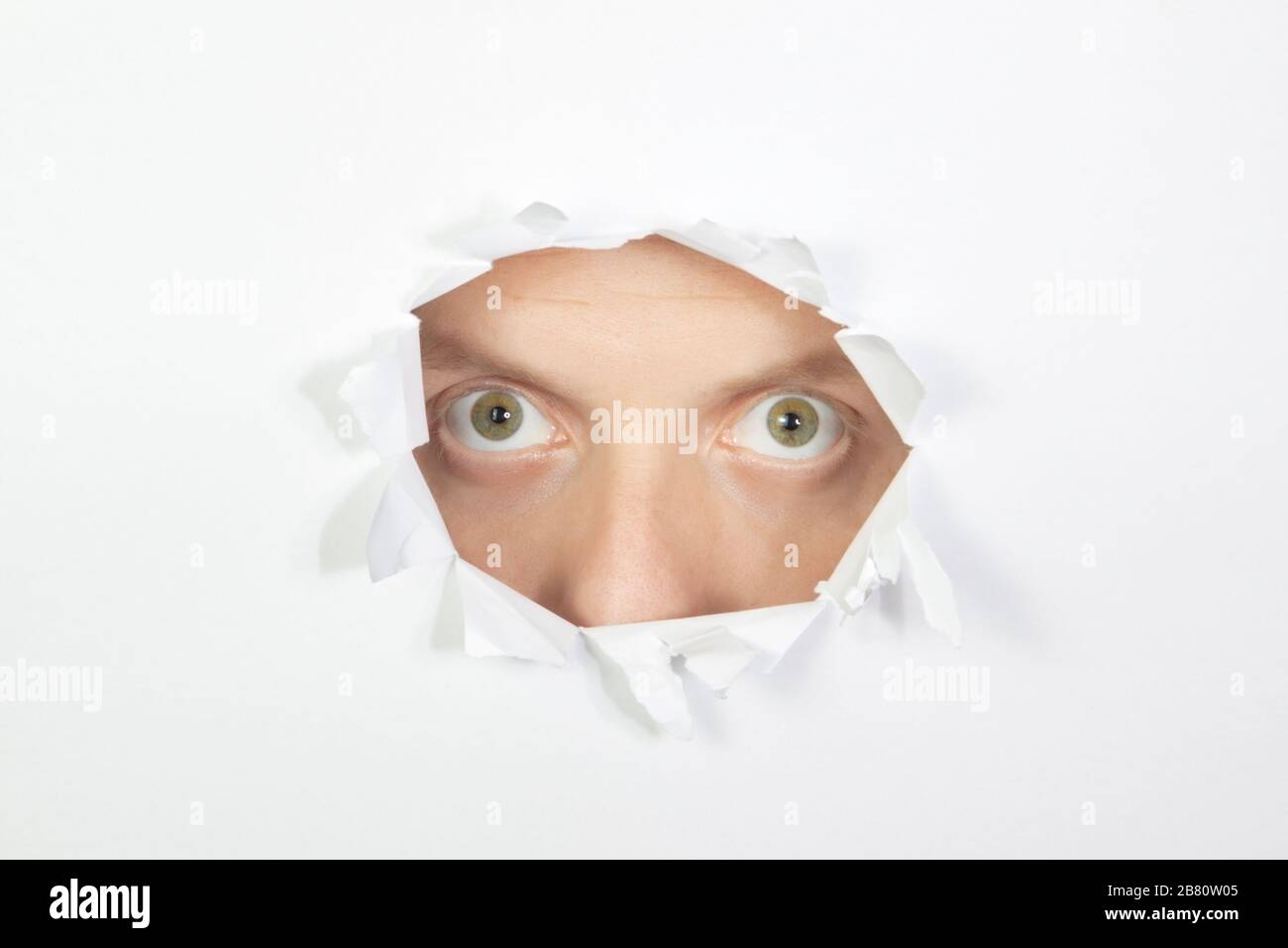 A terrible sight through the hole in the paper Stock Photo - Alamy