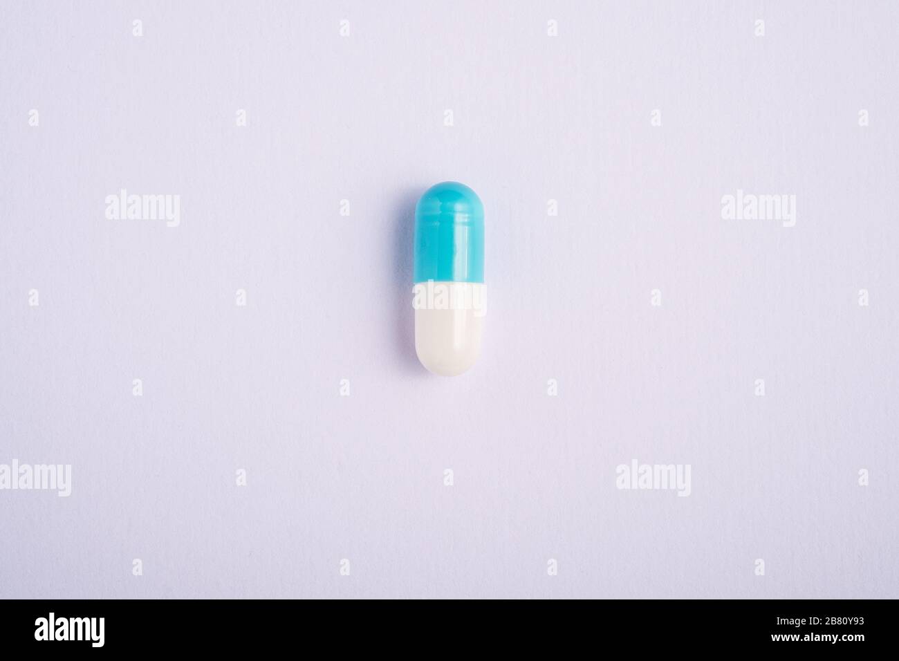 Single blue pill on bright white background, healthcare medical concept ...