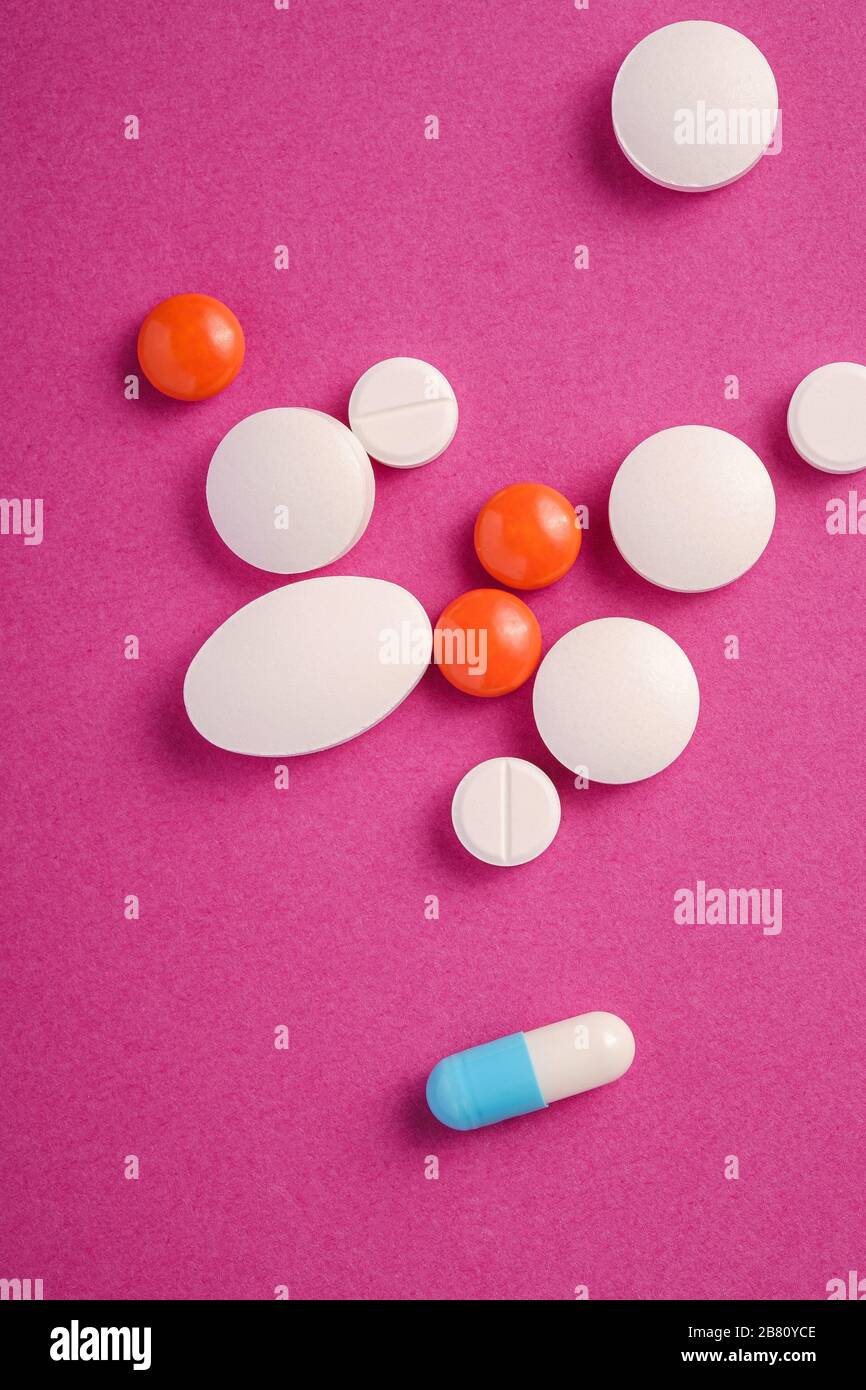 Pills and tablets on bright pink purple background, healthcare medical ...