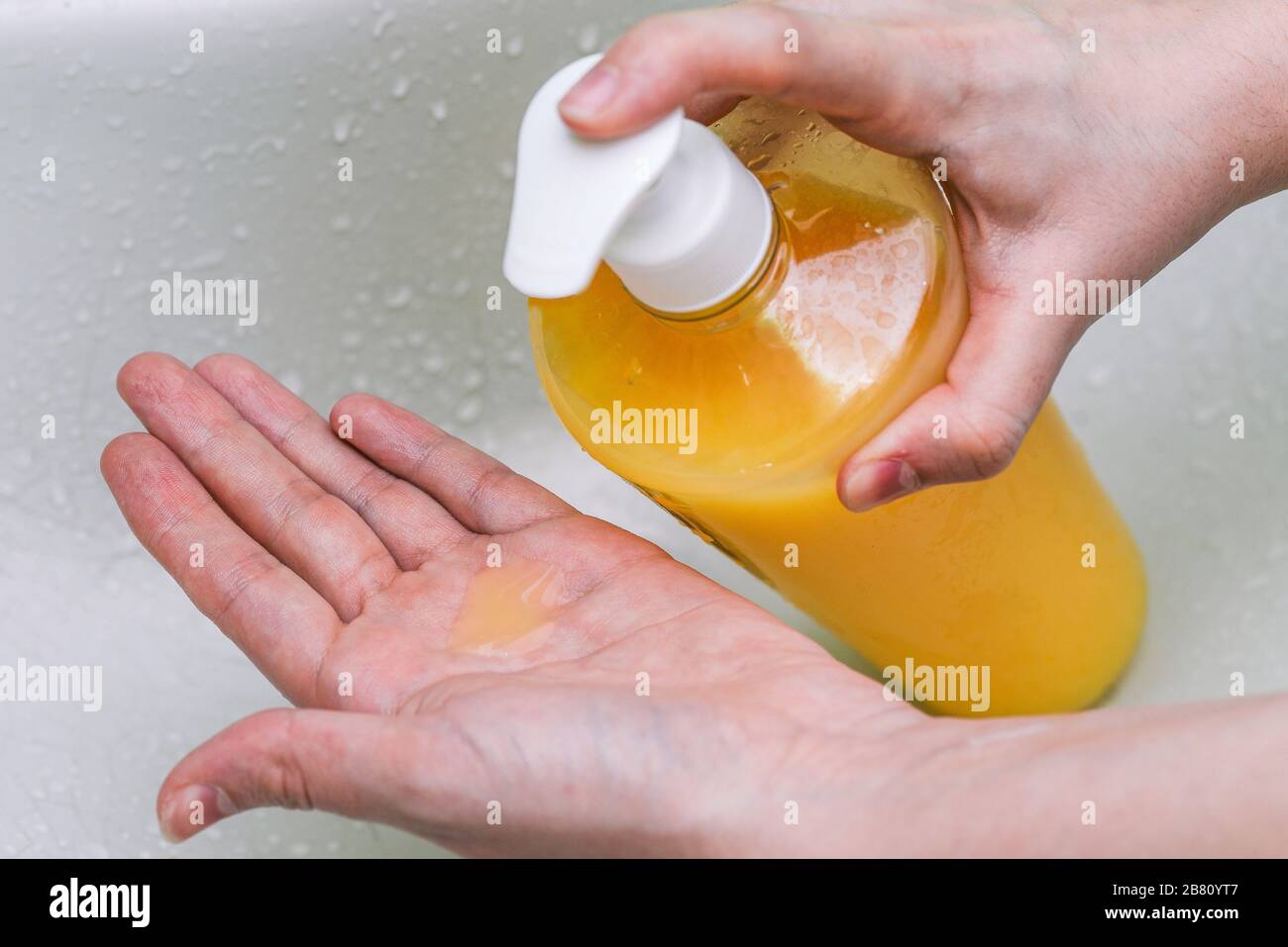 Soap for washing hands. Female hands hold a bottle with liquid ...