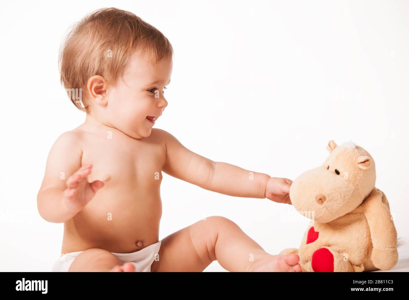 Front view of adorable kid playing with bear toy. Isolated on white ...
