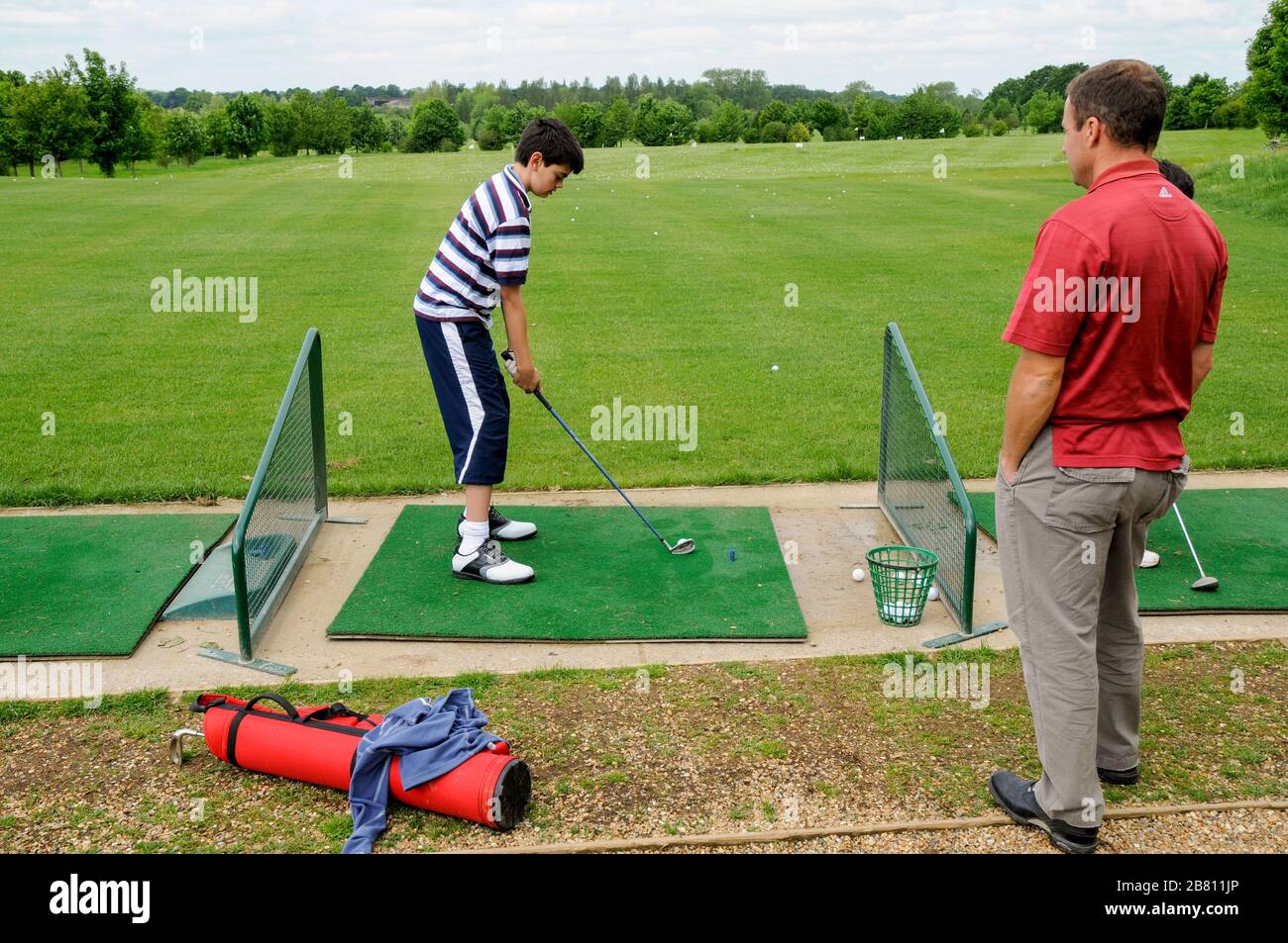 A young boy golfer demonstrating his teeing off skills under the ...