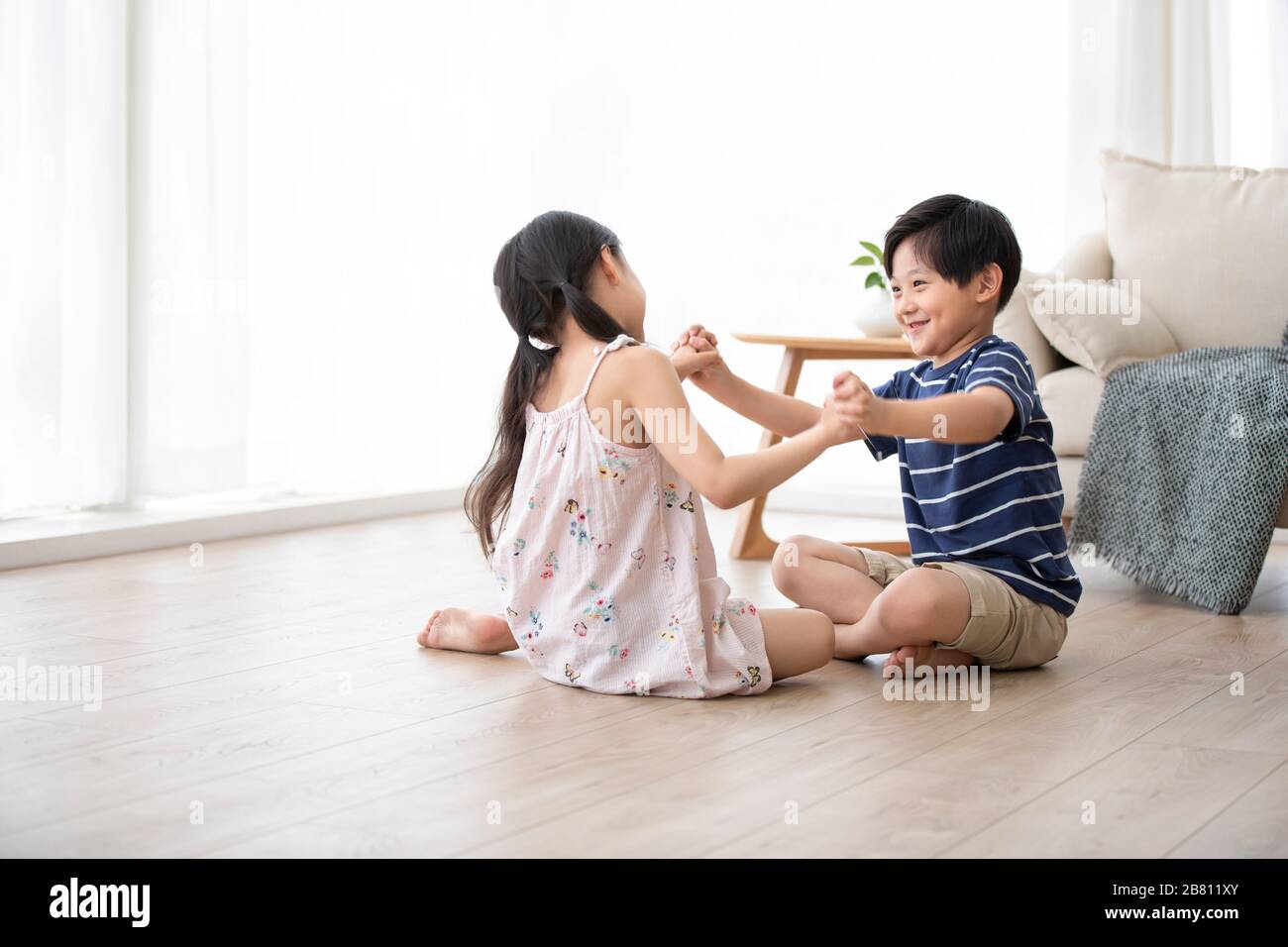 Happy Chinese sibling playing in living room Stock Photo - Alamy