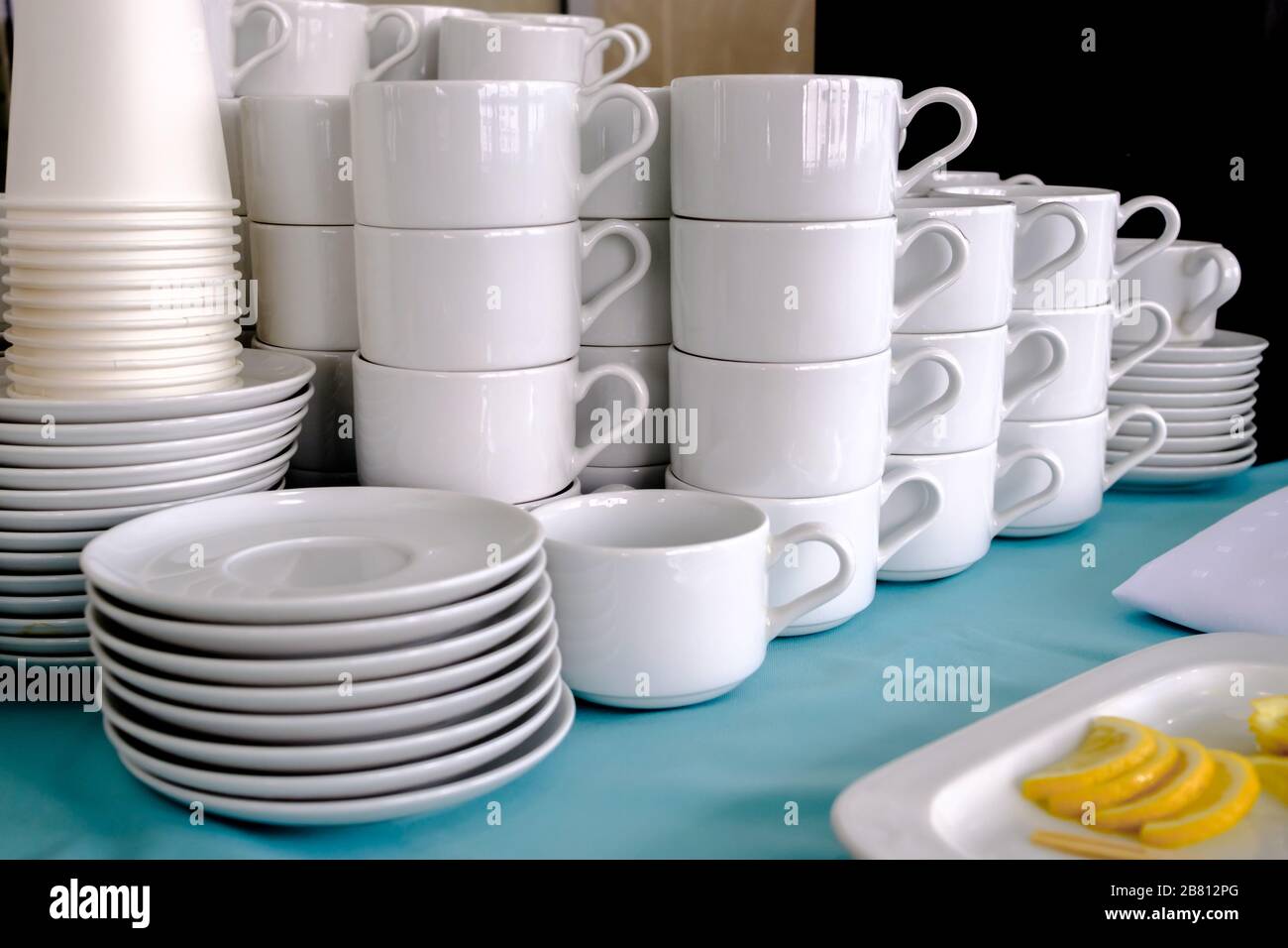 Exposed on stacks of white clean ceramic cups and saucers. The dishes ...