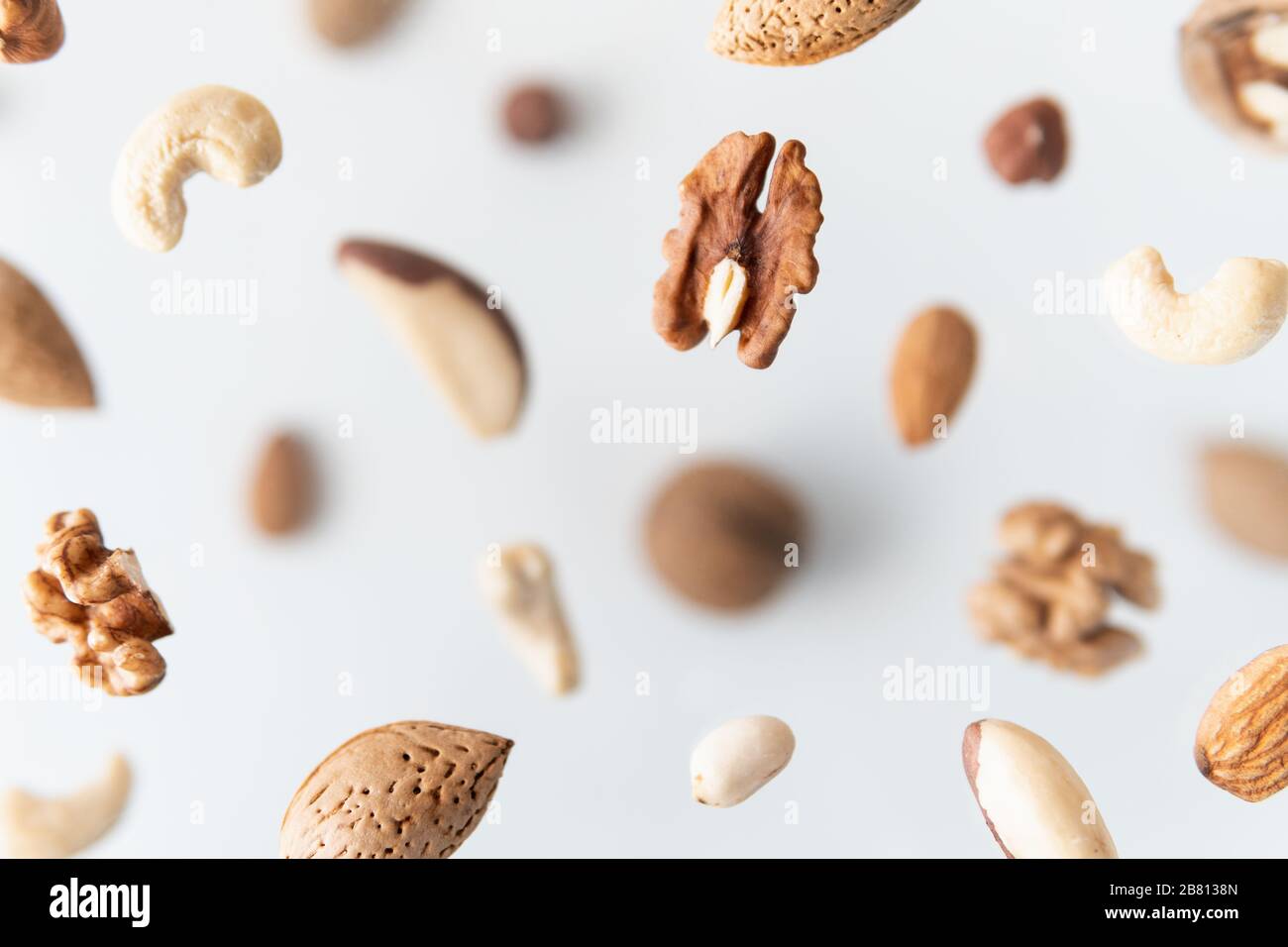 Assortment of mixed nuts flying above white background, levitation ...