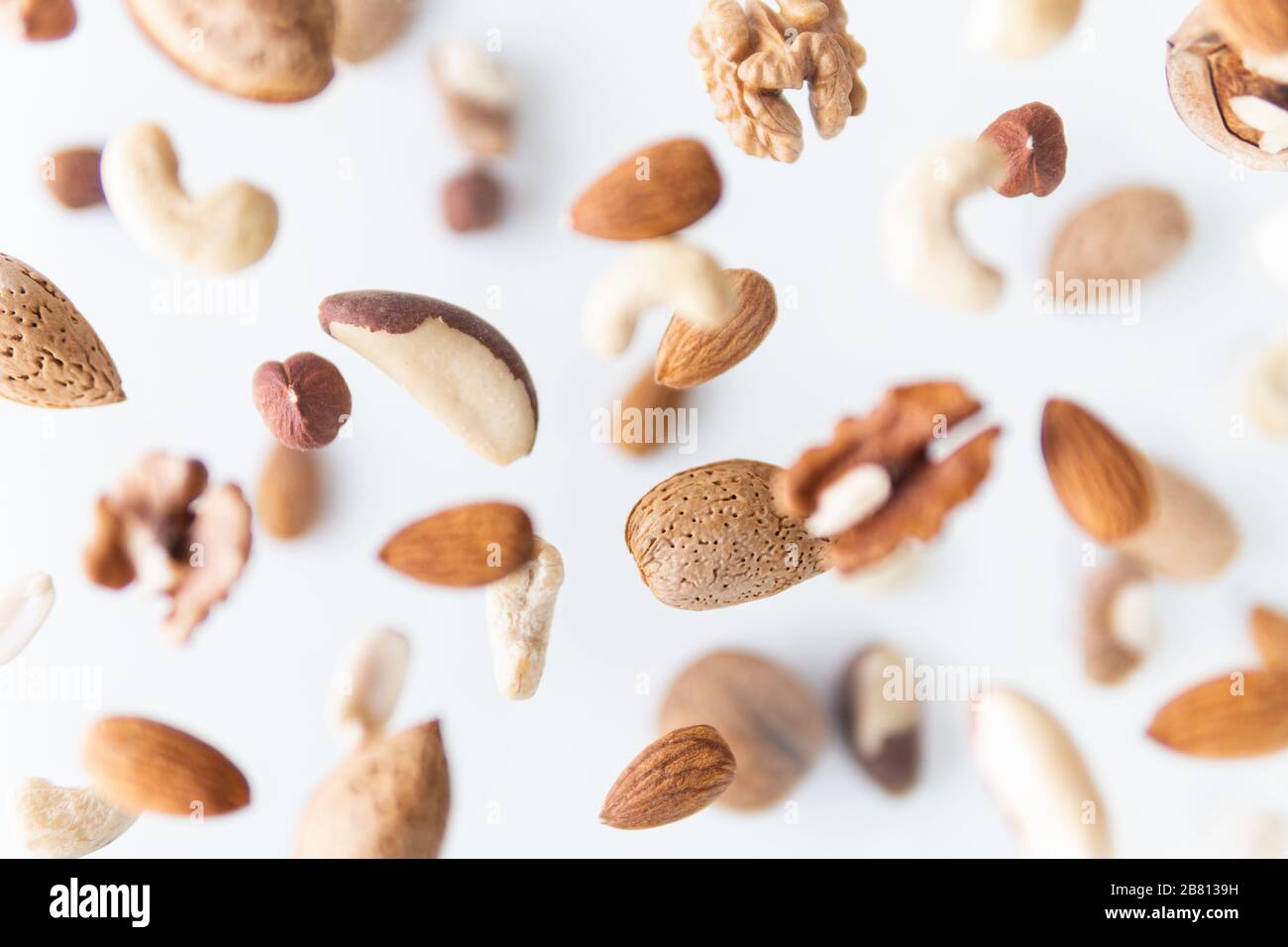 Assortment of mixed nuts flying above white background, levitation ...