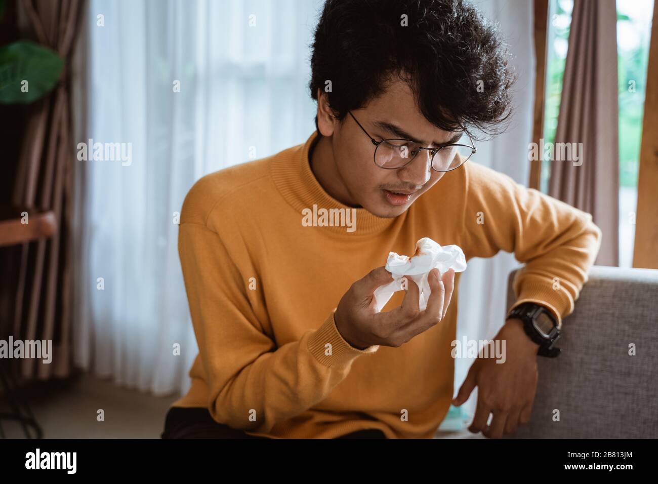 Man blood coughing wipe it with tissue at home Stock Photo - Alamy