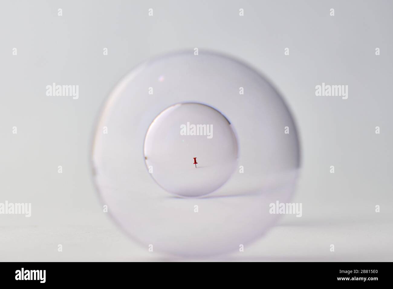 red pin behind eyeglass lens. vision disorders photo concept Stock ...