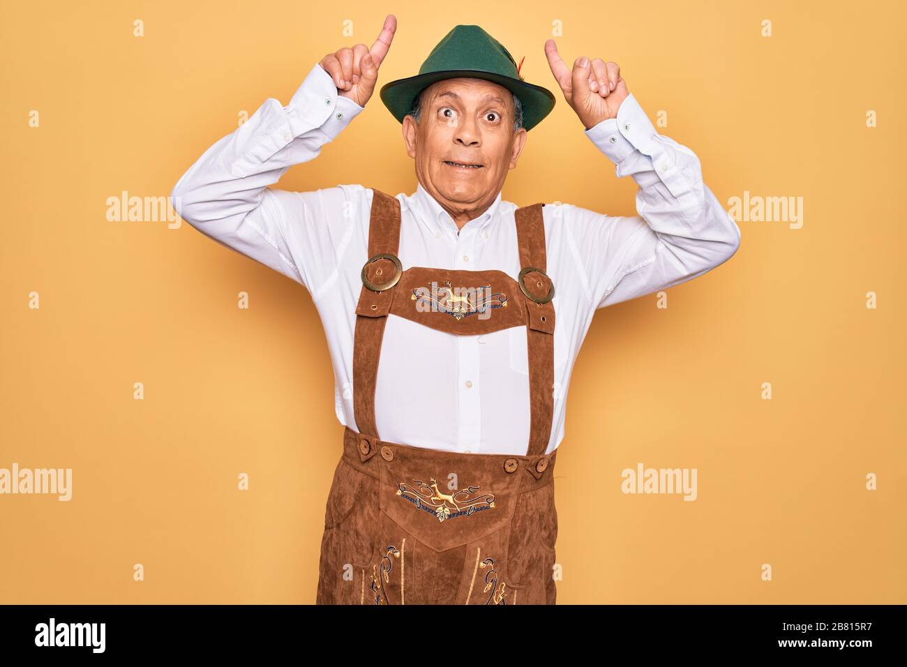 Senior grey-haired man wearing german traditional octoberfest suit over ...