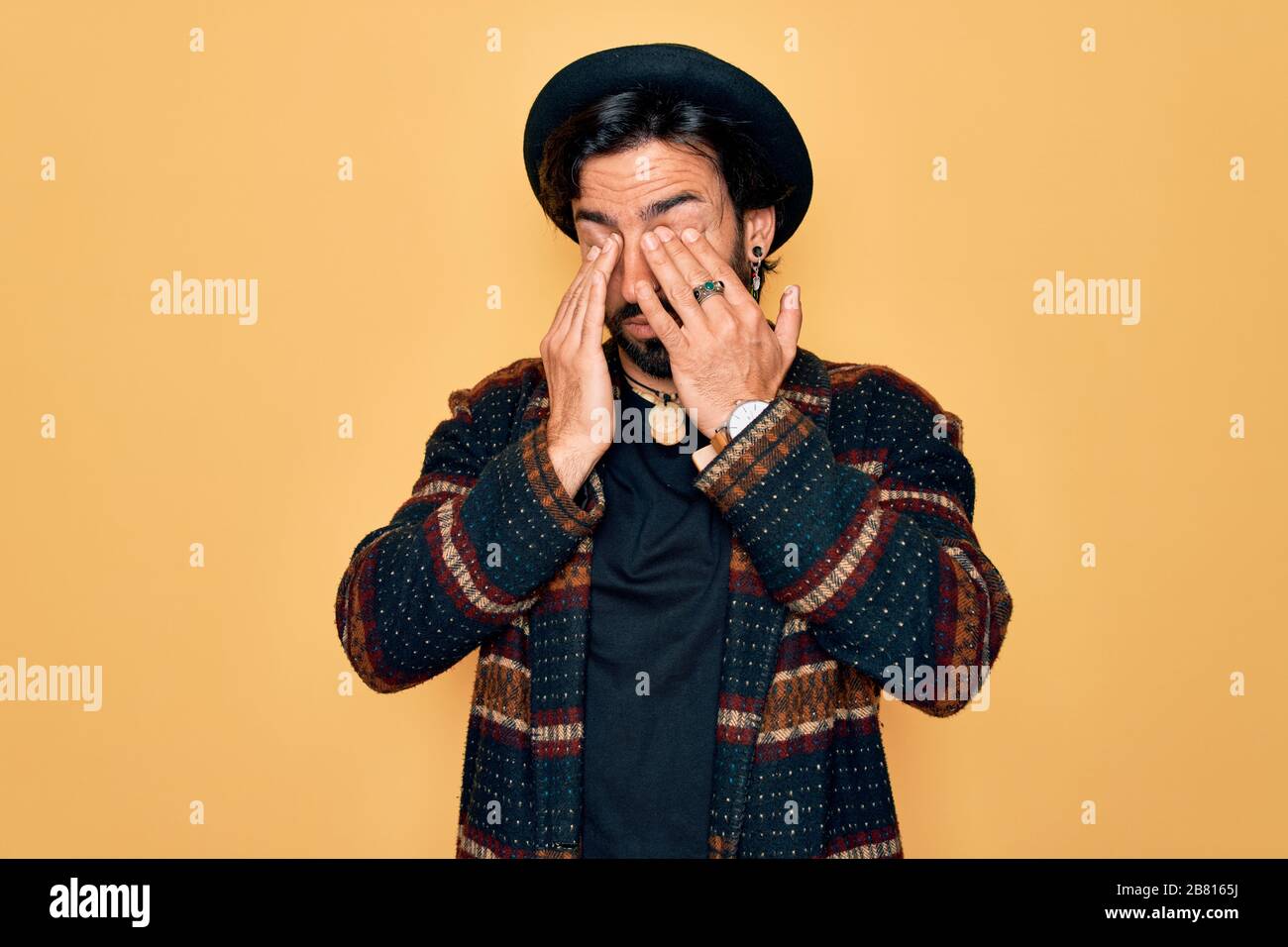 Young handsome hispanic bohemian man wearing hippie style and boho hat ...