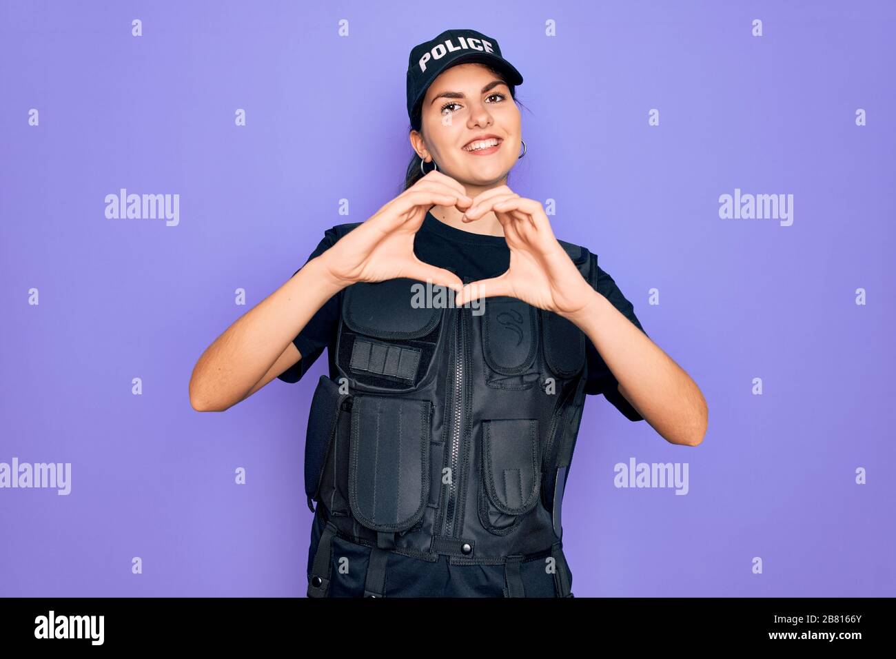 Young police woman wearing security bulletproof vest uniform over ...