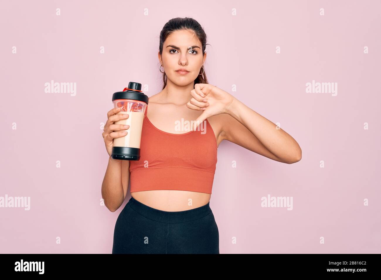 Young beautiful fitness woman wearing sport excersie clothes drinking ...