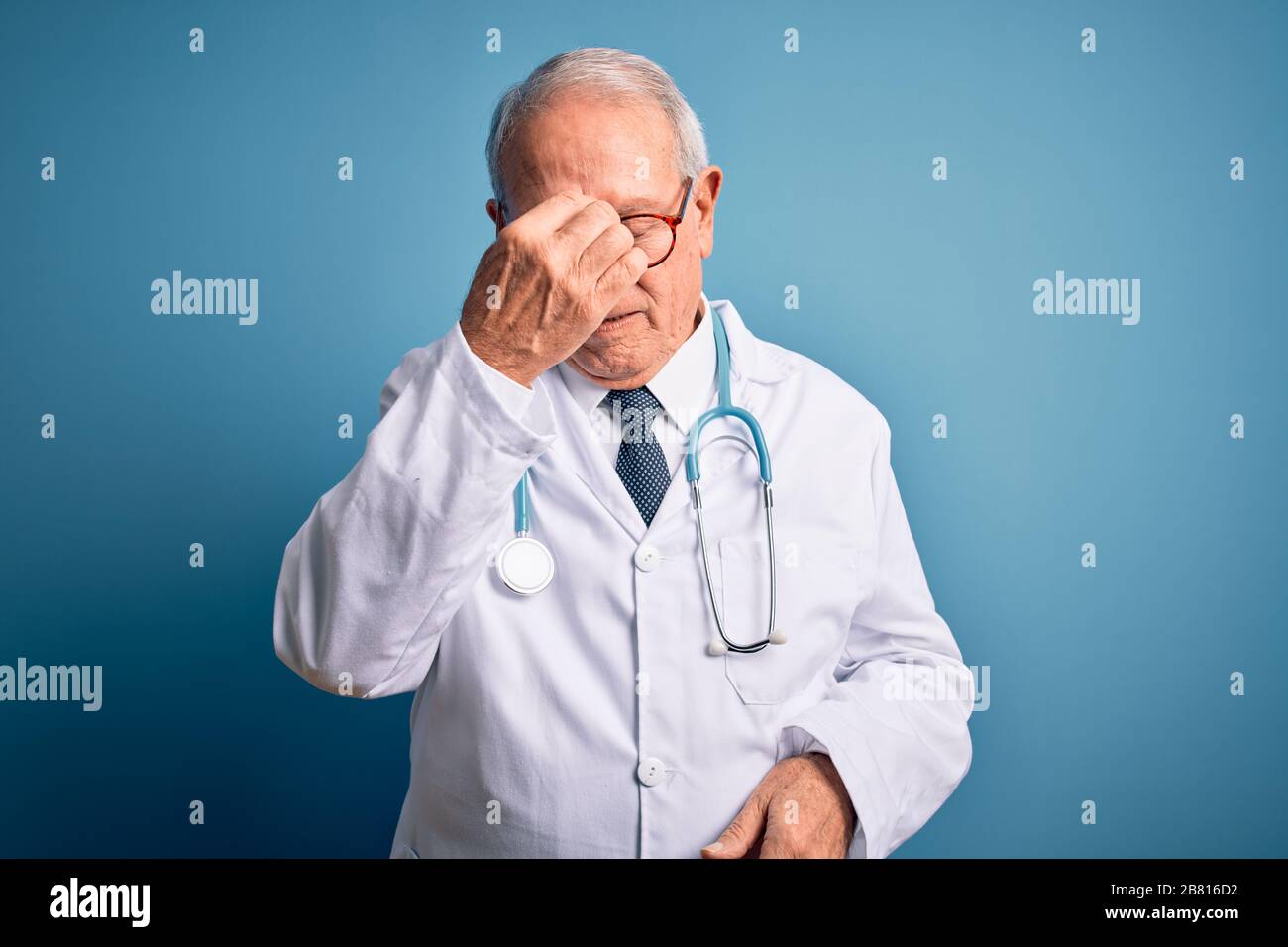 Senior grey haired doctor man wearing stethoscope and medical coat over ...