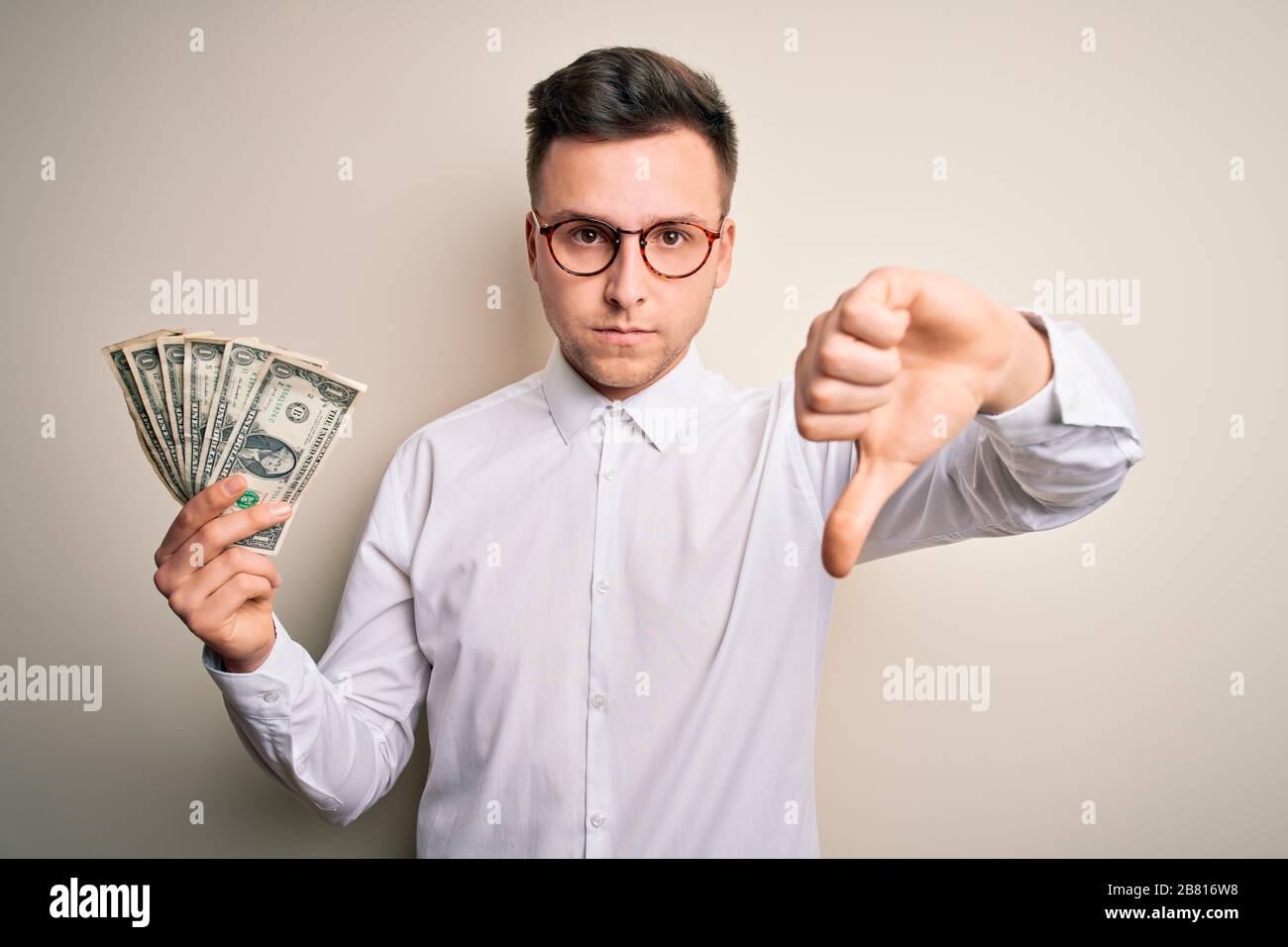 Young handsome caucasian business man holding bunch of one dollar ...