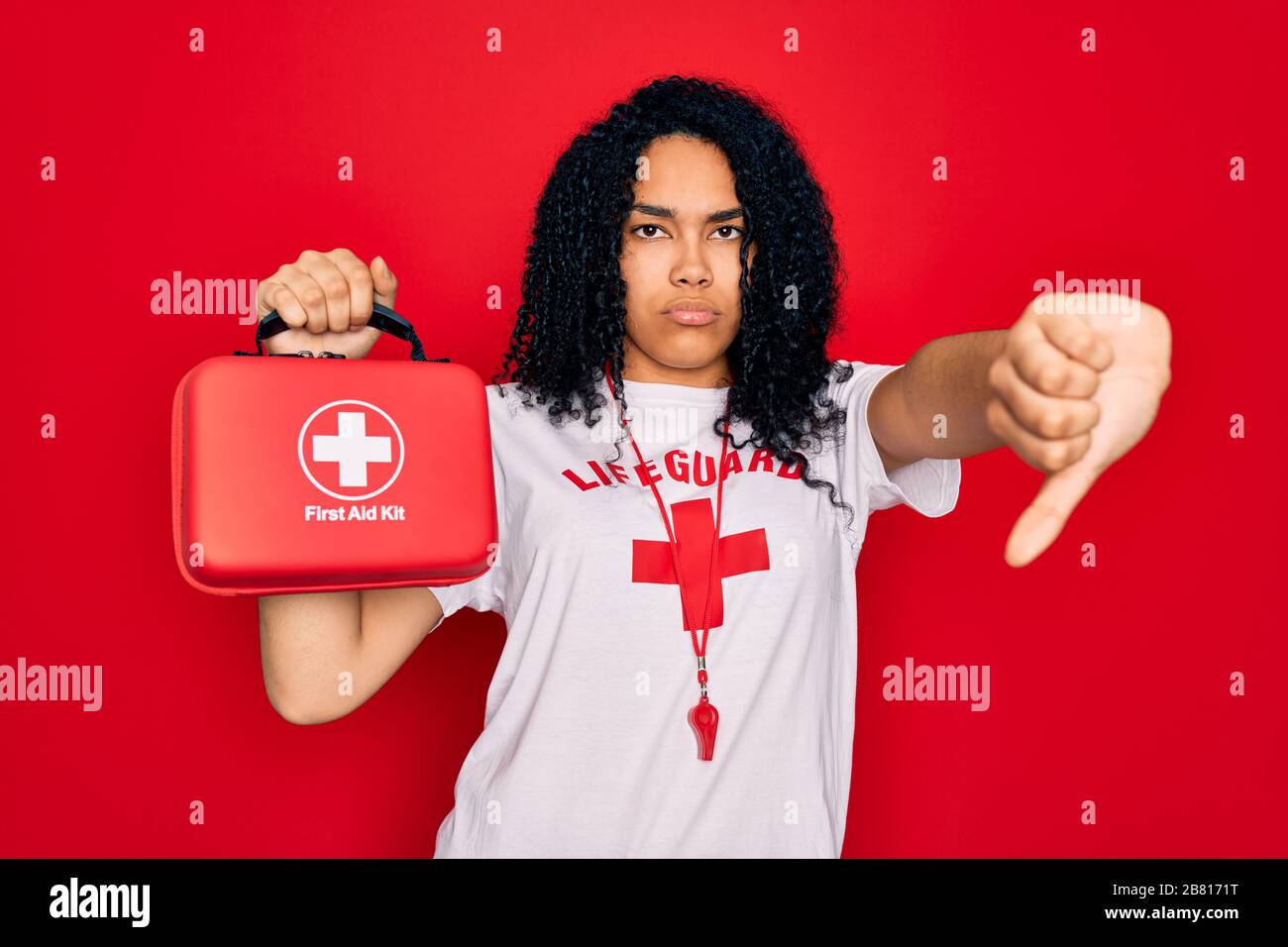 Young african american curly lifeguard woman wearing whistle holding ...