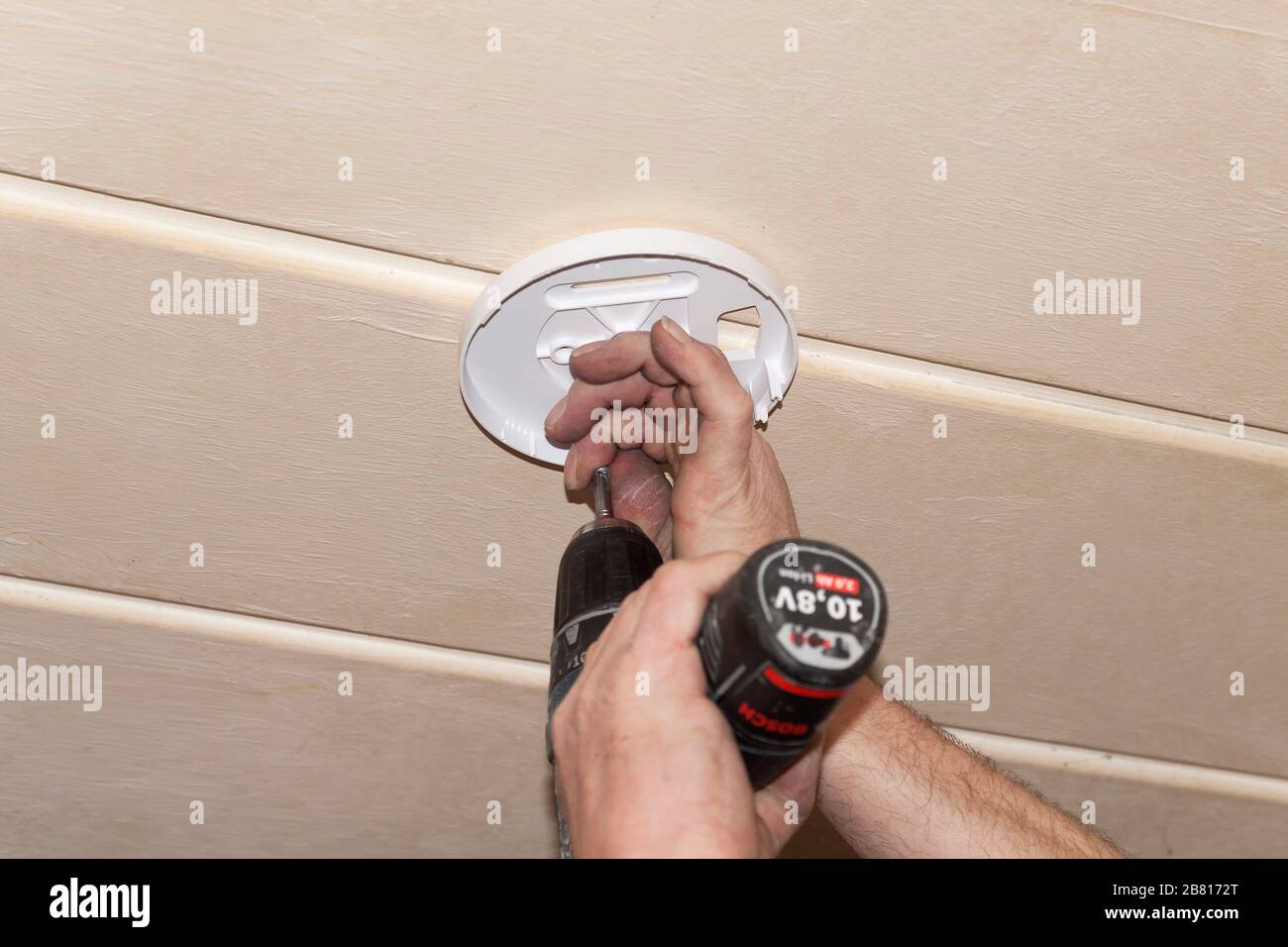 Smoke alarm on a ceiling,Installation of a smoke detector on a ceiling ...