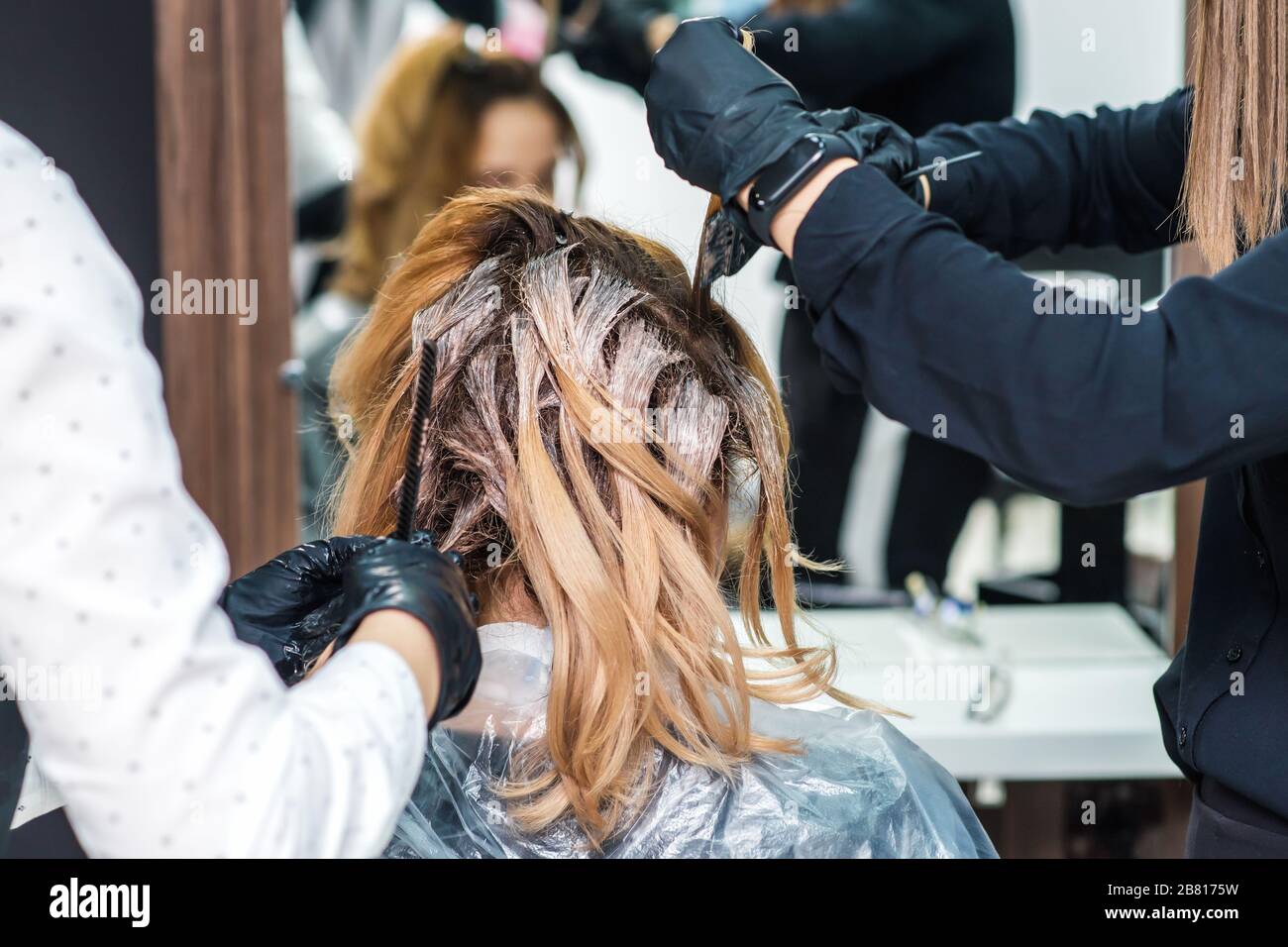 Hairdresser colors hair of woman in hair salon Stock Photo - Alamy