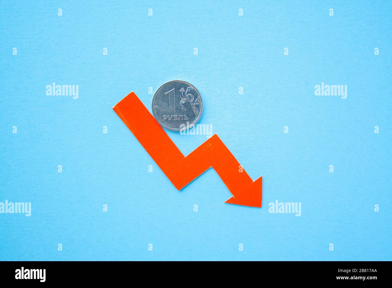 one rouble coin on blue background with red arrow down. exchange rate ...