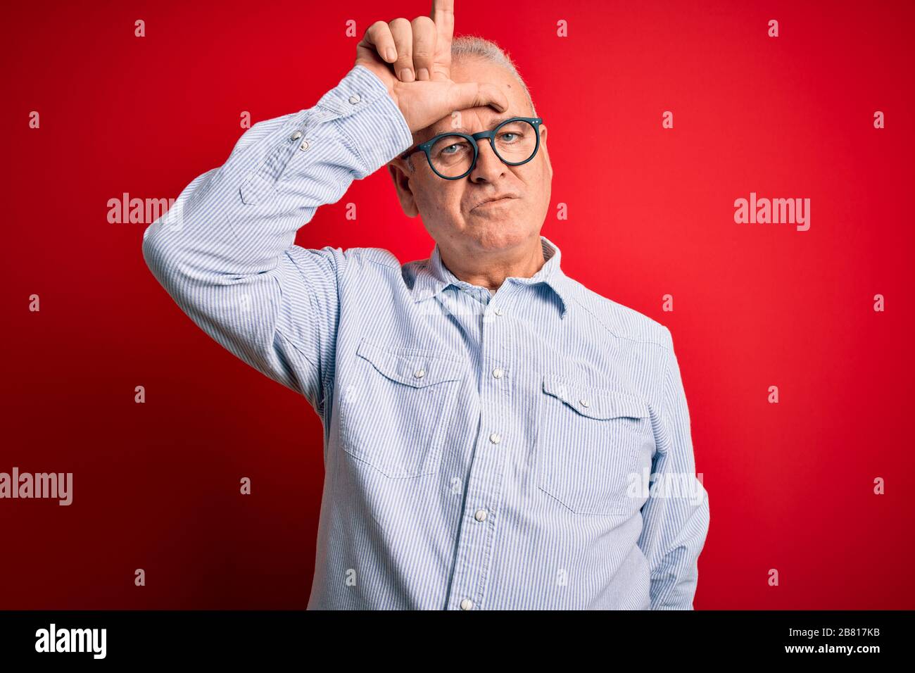 Middle age handsome hoary man wearing casual striped shirt and glasses ...