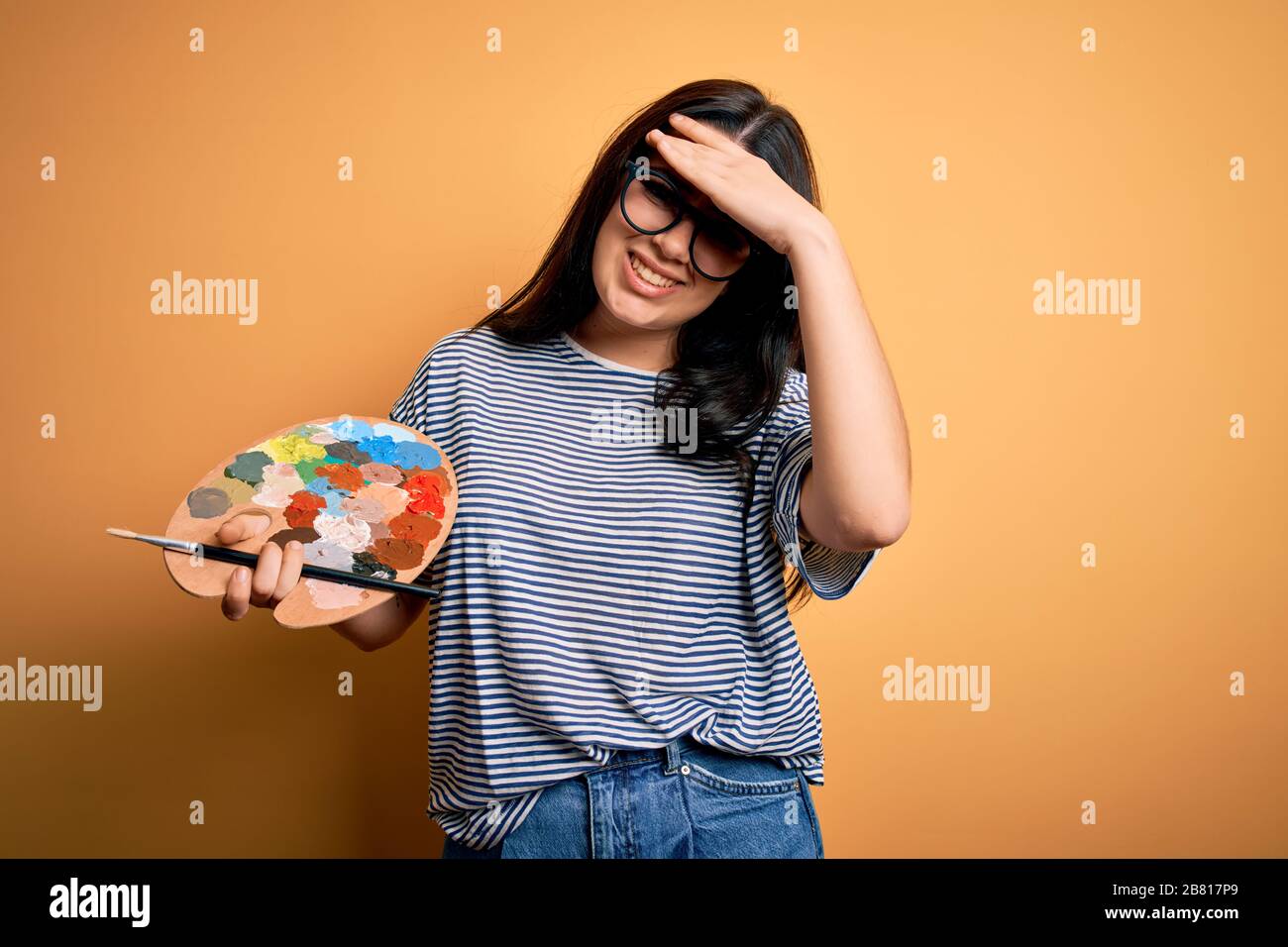 Young brunette artist woman painting holding painter brush and palette ...