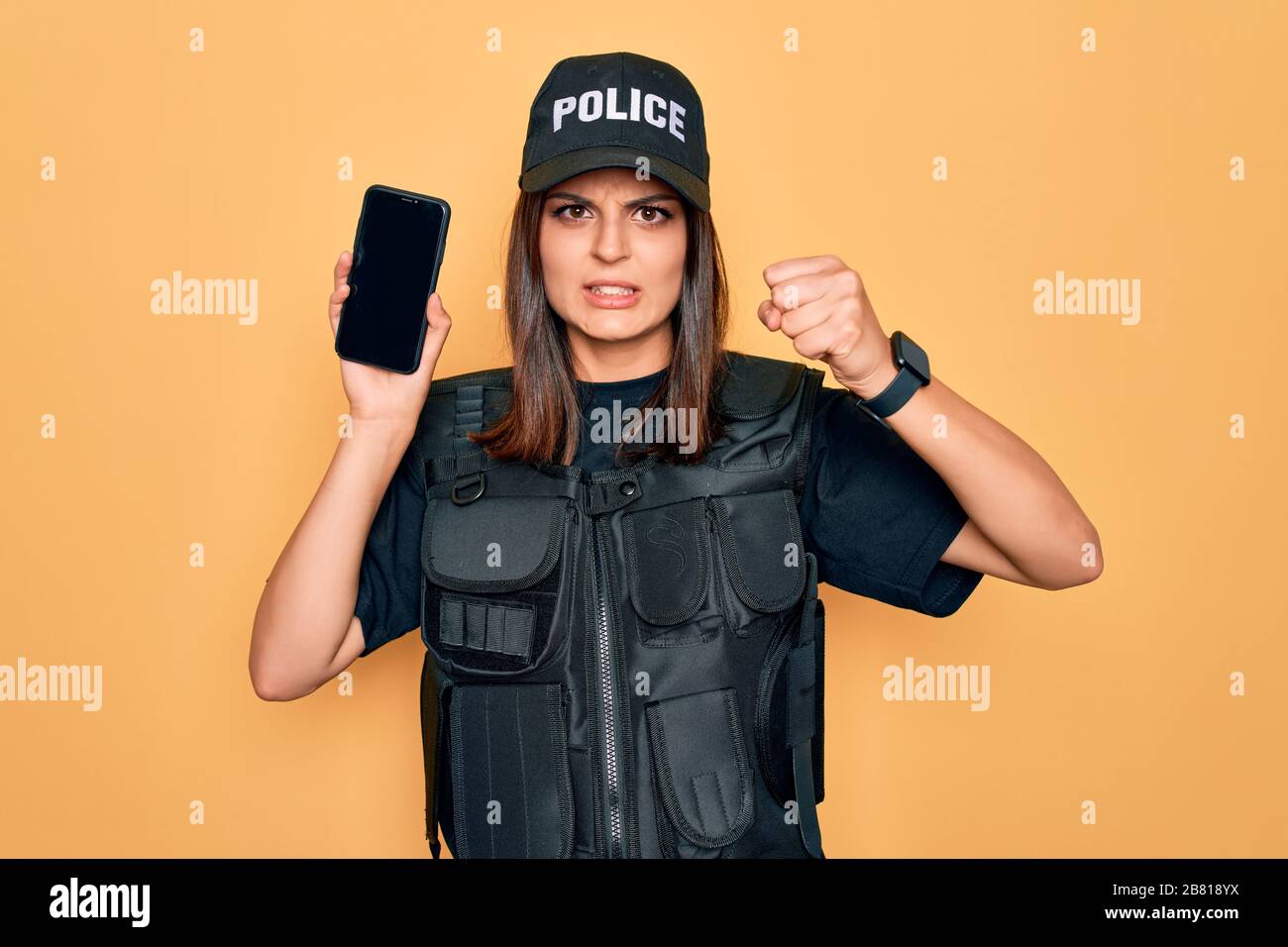 Beautiful brunette policewoman wearing police uniform holding ...