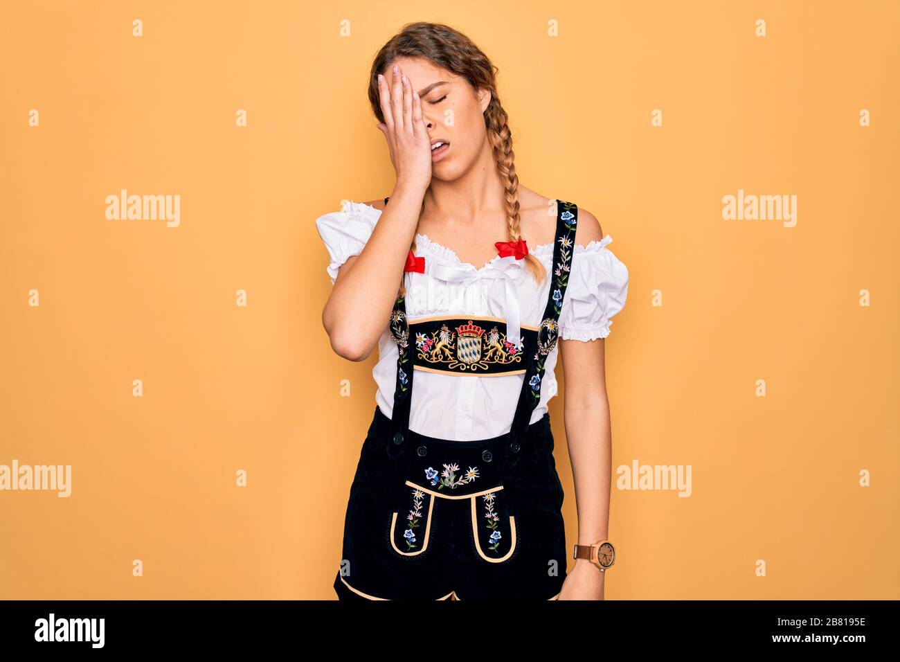 Young beautiful blonde german woman with blue eyes wearing traditional ...