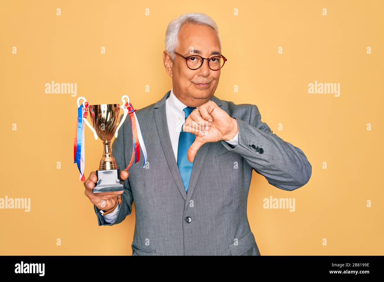 Middle age senior grey-haired business man wearing glasses holding ...