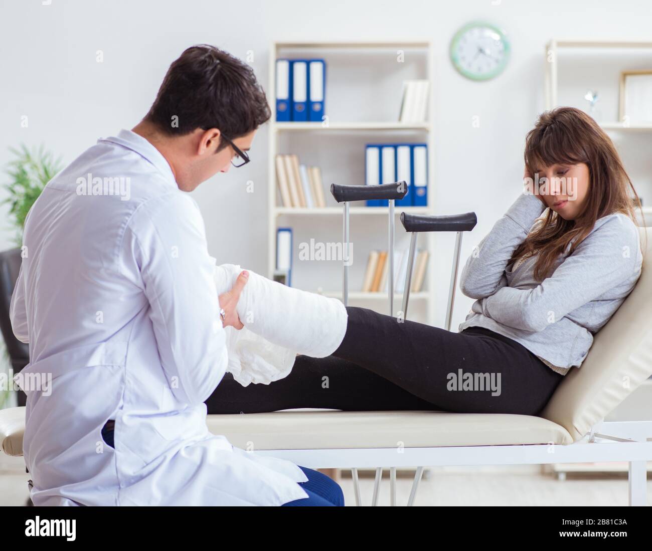 The doctor examining patient with broken leg Stock Photo - Alamy