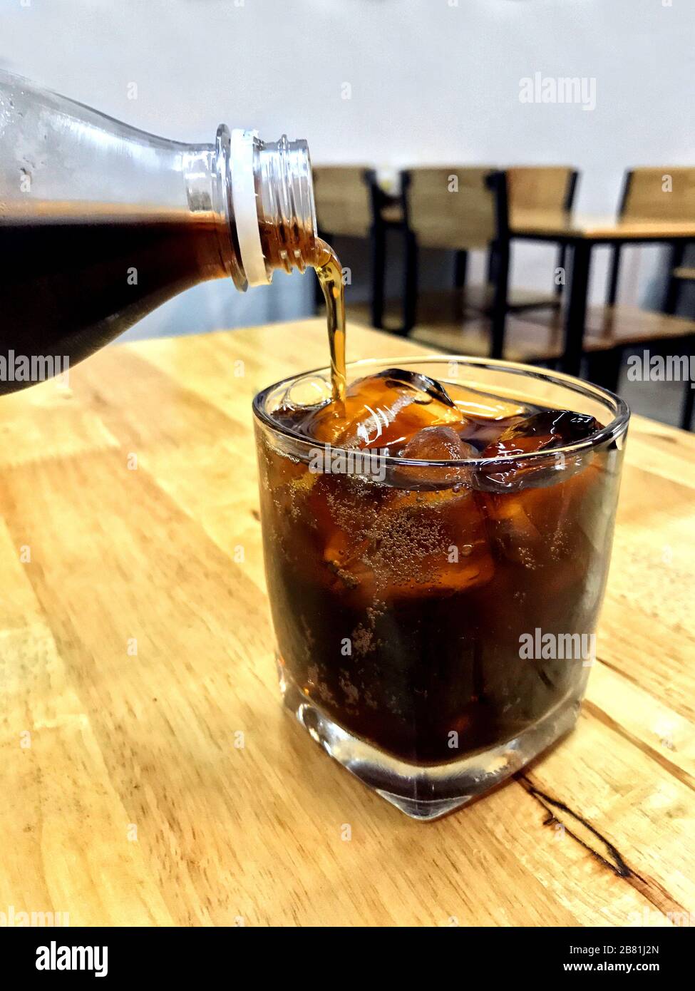 Cola in glass ice, Pouring cola from glass bottles drinks to a glass ...
