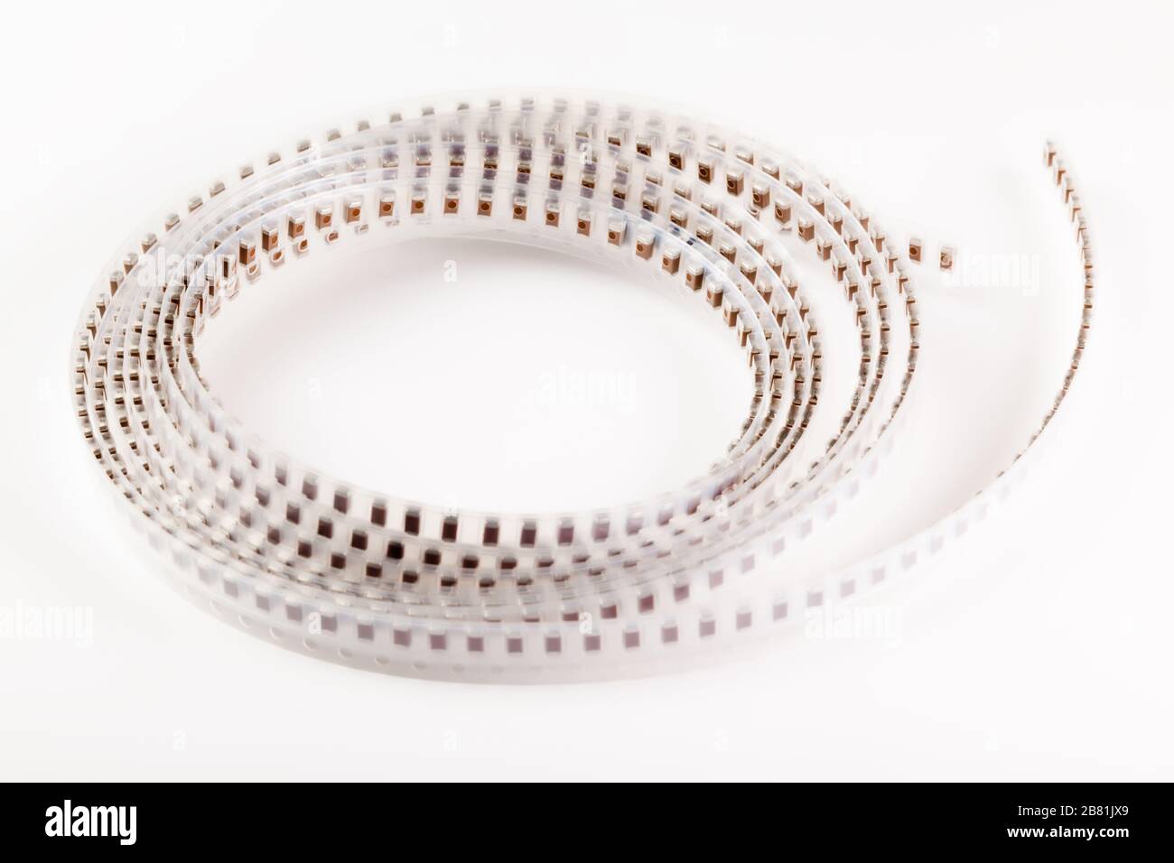 Photo of electrical part plastic tape with capacitors for electronic ...