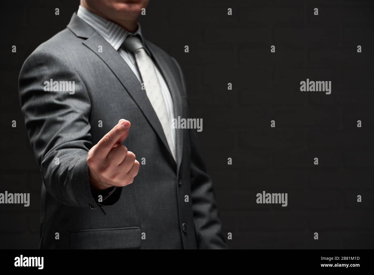 businessman demonstrating something in his fingers, dressed in gray ...