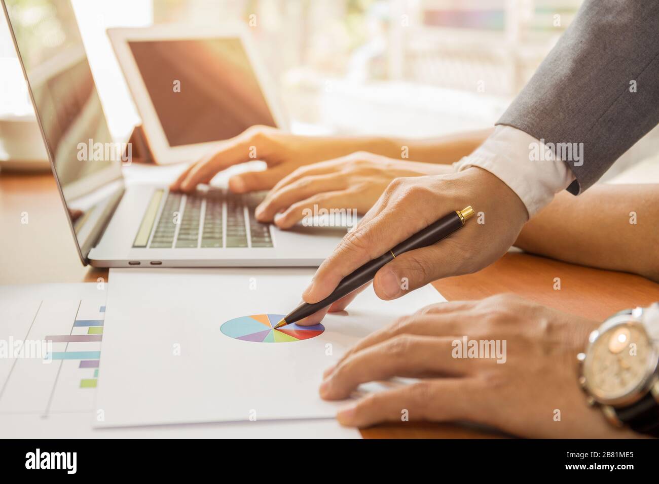 Business people hands pointing at documents charts and graphs financial ...